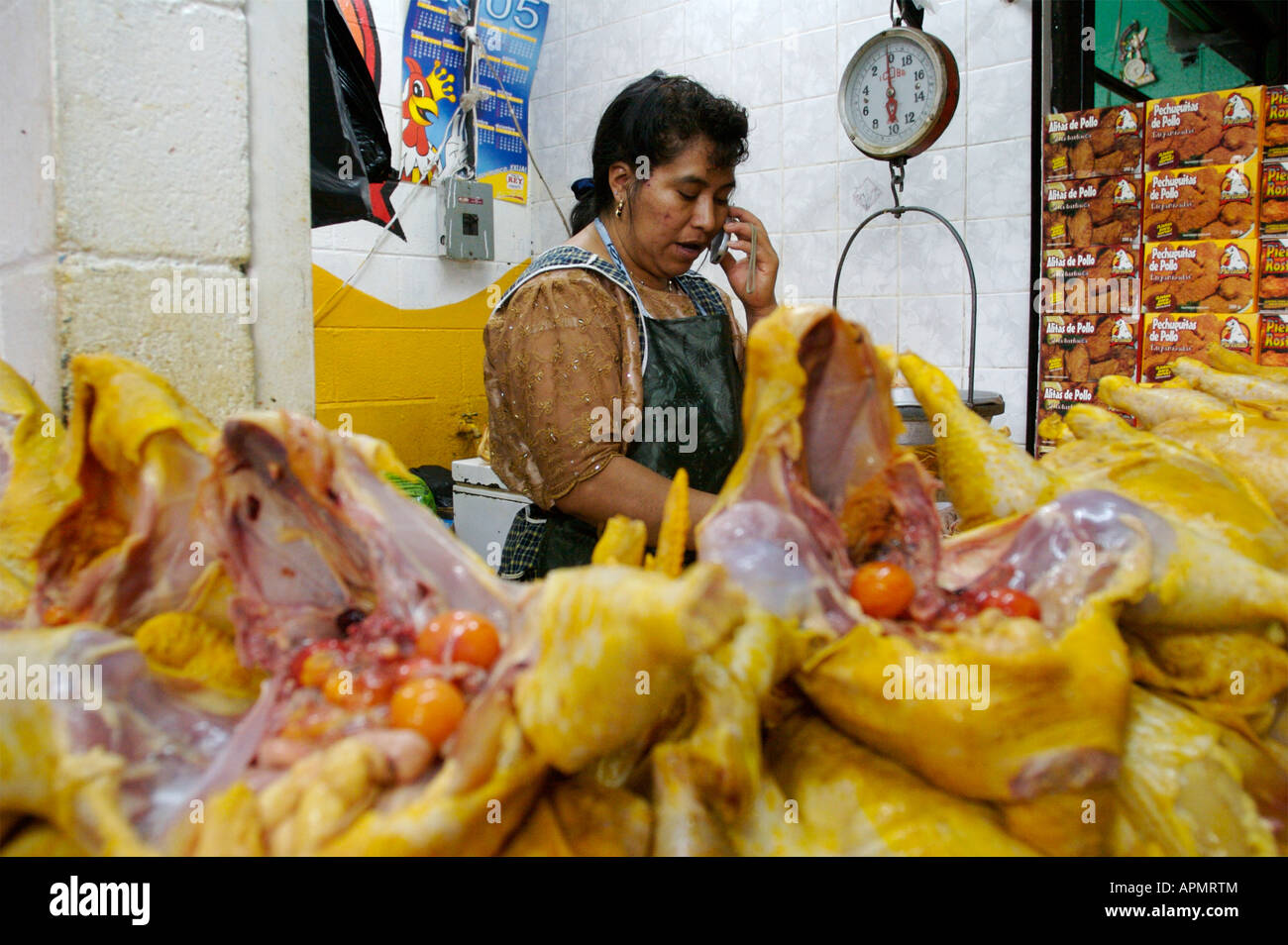 A woman takes a phone call while working in a poultry butcher shop ...