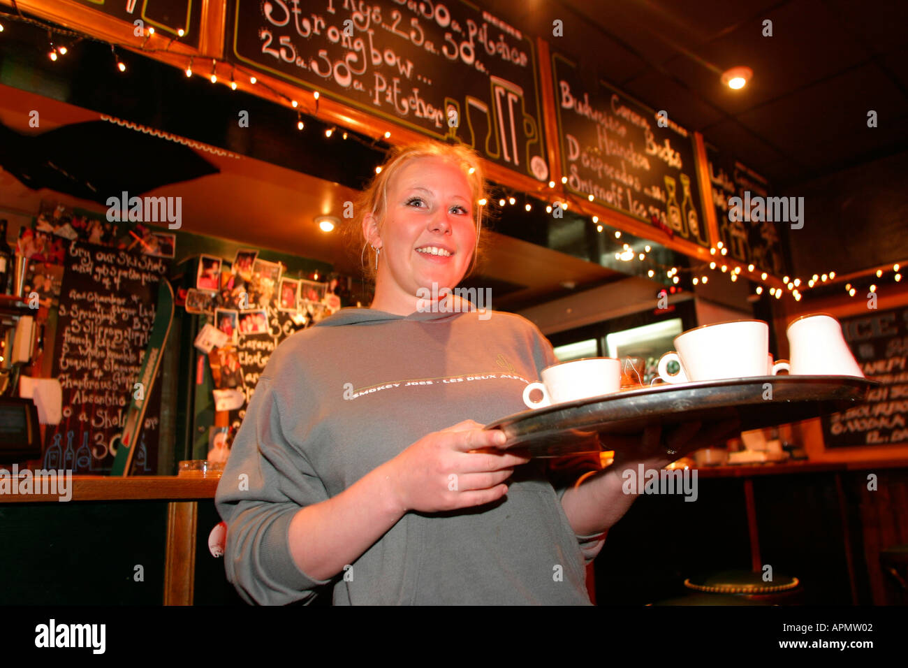 BARMAID SERVING DRINKS IN BAR APRES SKI MOUNTAIN RESORT Stock Photo - Alamy