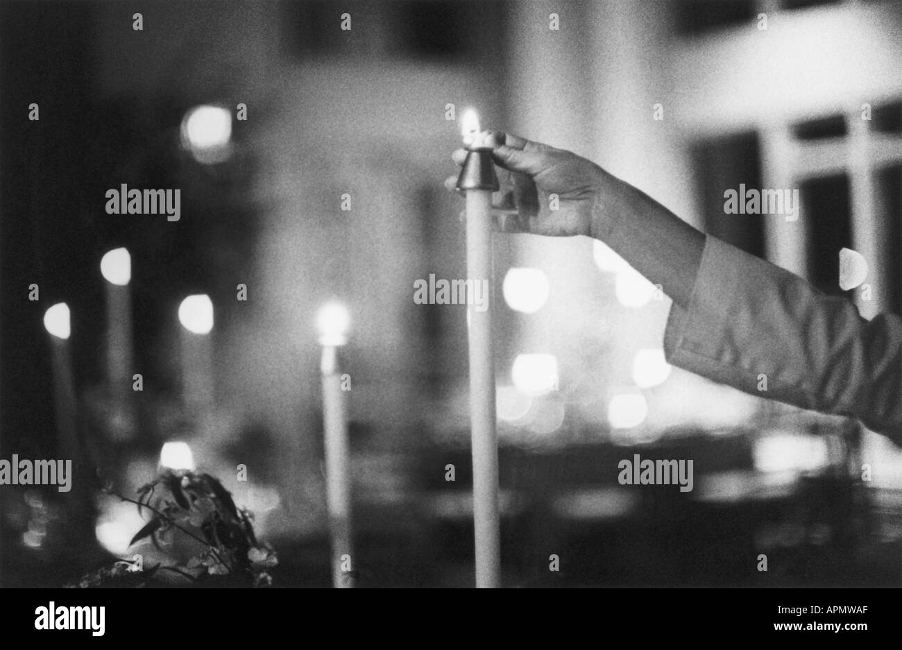 Hand lighting a candle Stock Photo - Alamy