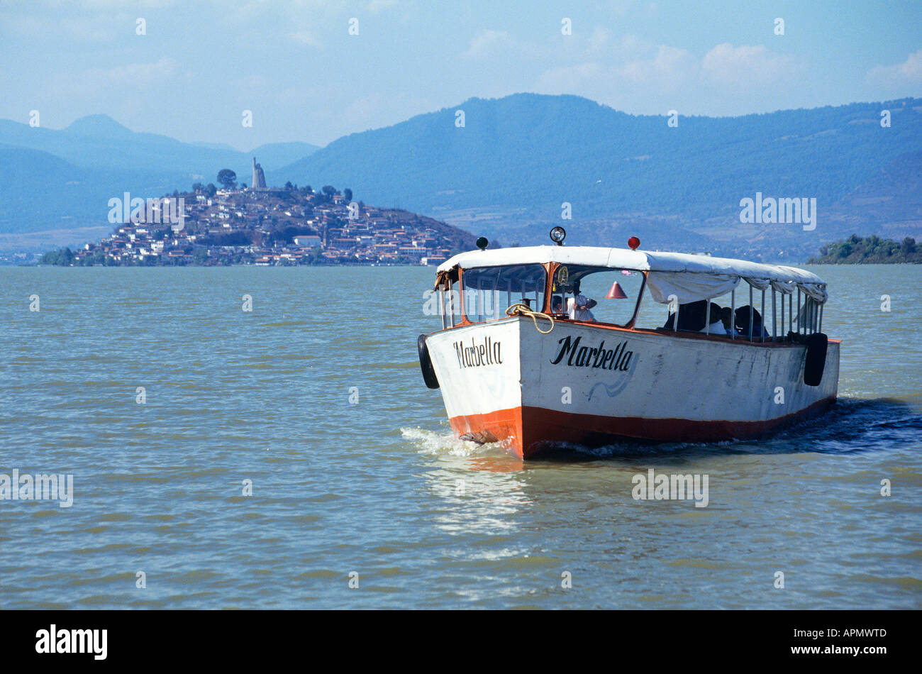 A ferry boat with its name inscribed across the bows leaves behind the ...
