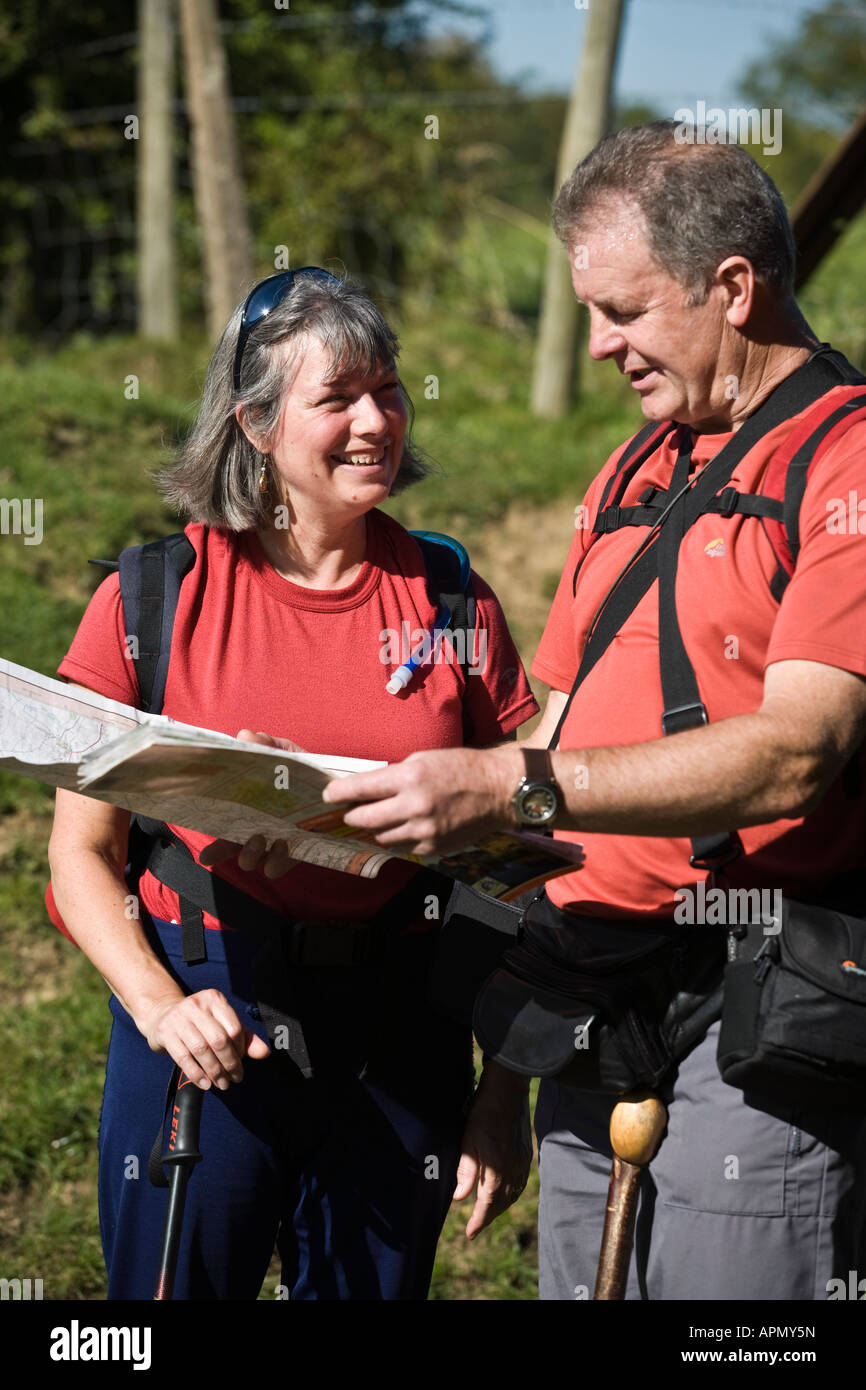 Two walkers in Cotswold countryside reading a map in the summer ...