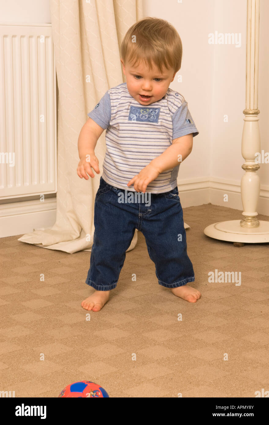 Baby boy eleven months old standing free attempting to take steps ...
