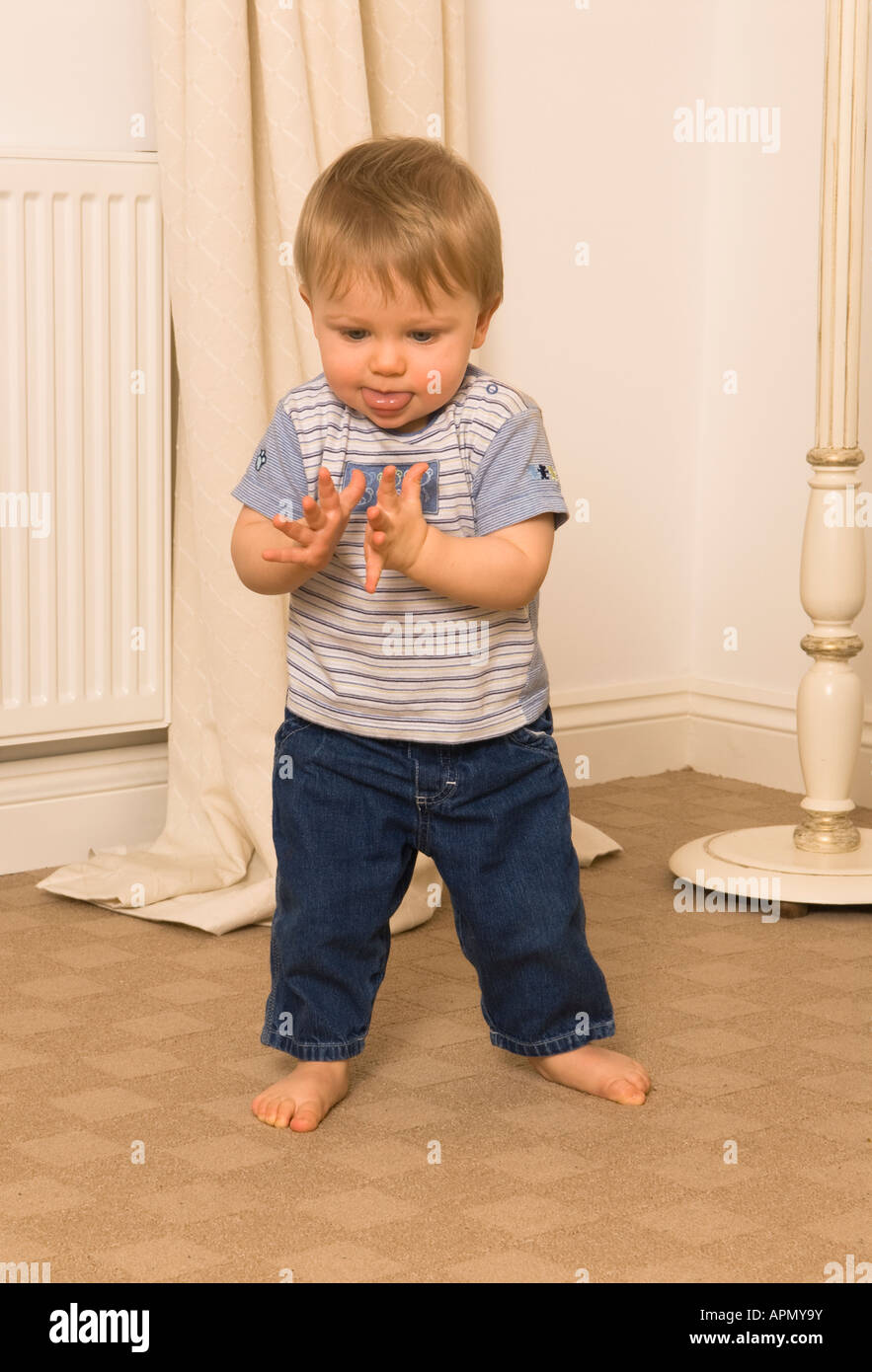 Baby boy eleven months old standing free attempting to take steps ...
