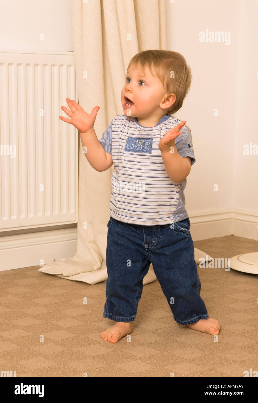 Baby boy eleven months old standing free attempting to take steps ...
