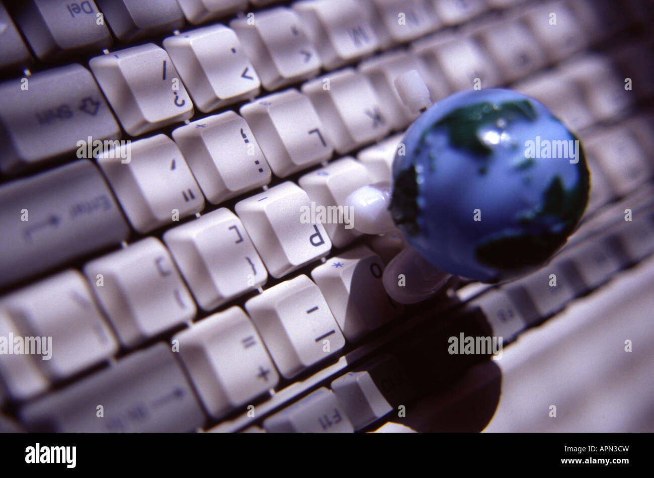 toy wind up gobe with feet resting on key on computer keyboard Stock ...