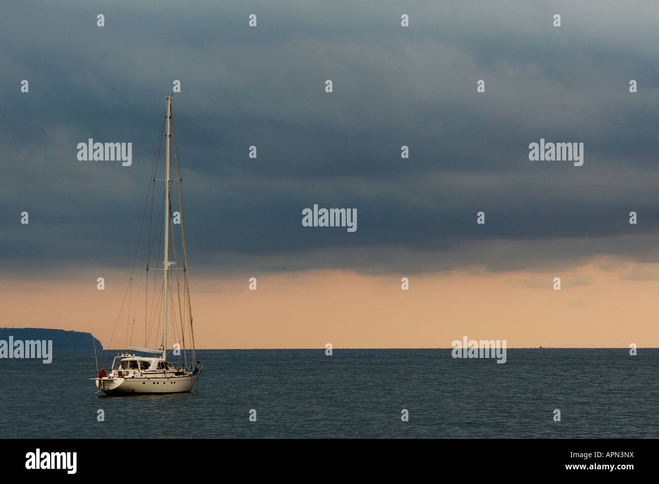 Landscape on the coast with sailboat Stock Photo - Alamy
