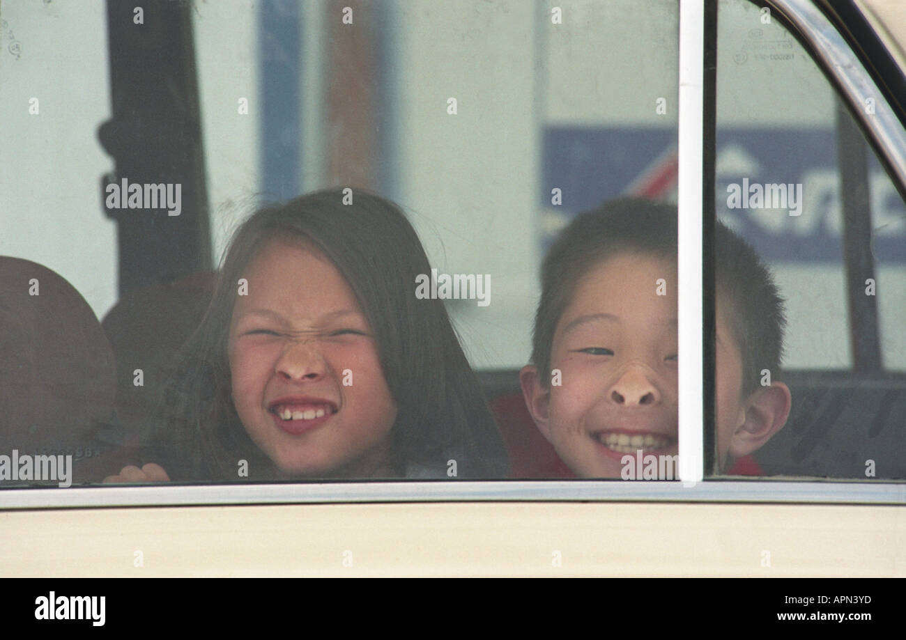 Children making faces through car window. Kosh Agach village. Altai ...