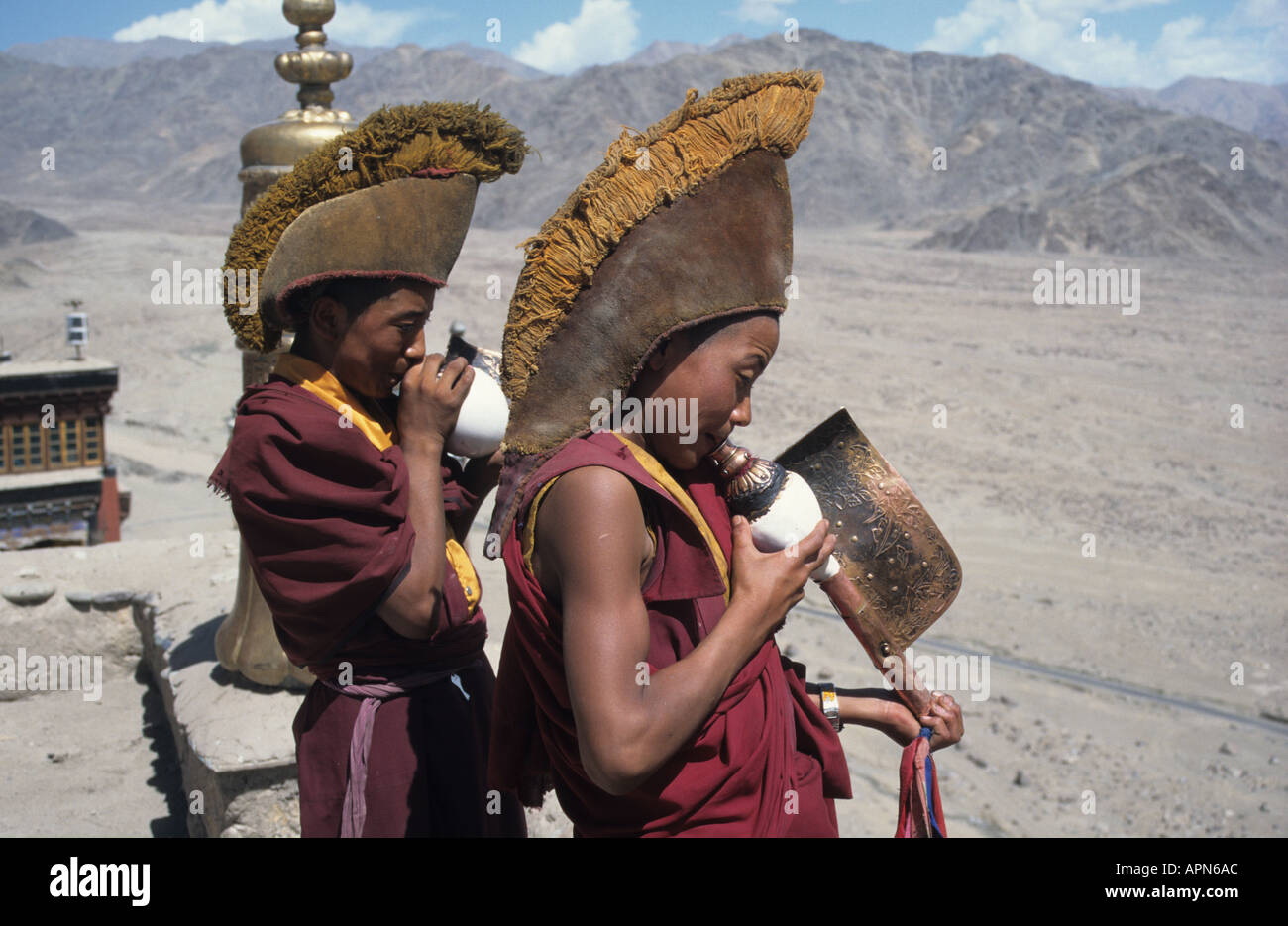 Novice monks blowing horns from the roof of the Thikse Gompa monastery ...