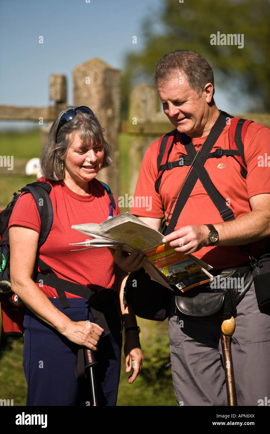 Two walkers in Cotswold countryside reading a map in the summer ...