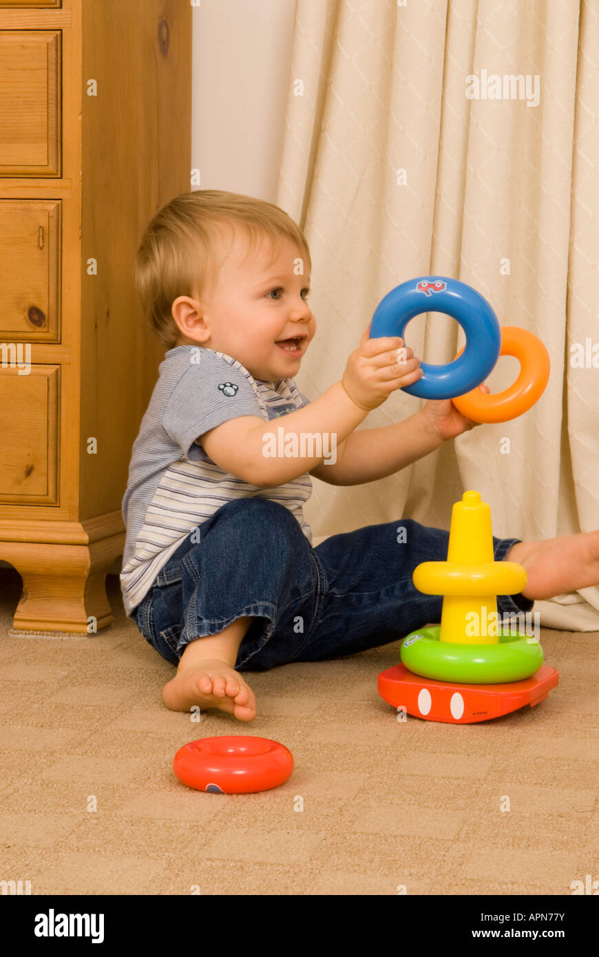 Baby boy eleven months old playing with graded rings educational toy ...