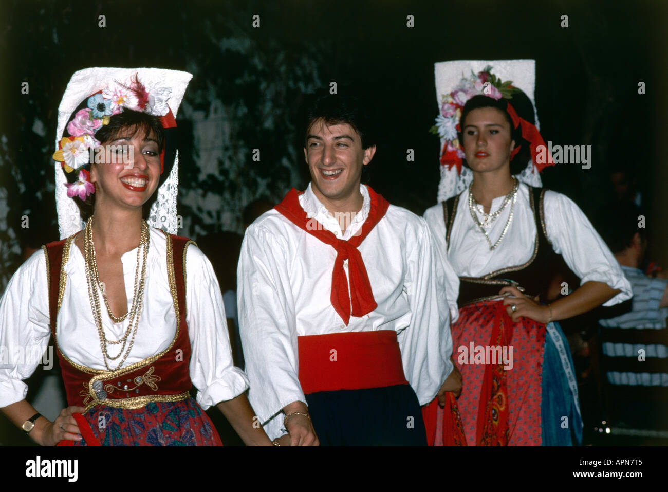 Two young Greek women and a man dressed in traditional costume ...