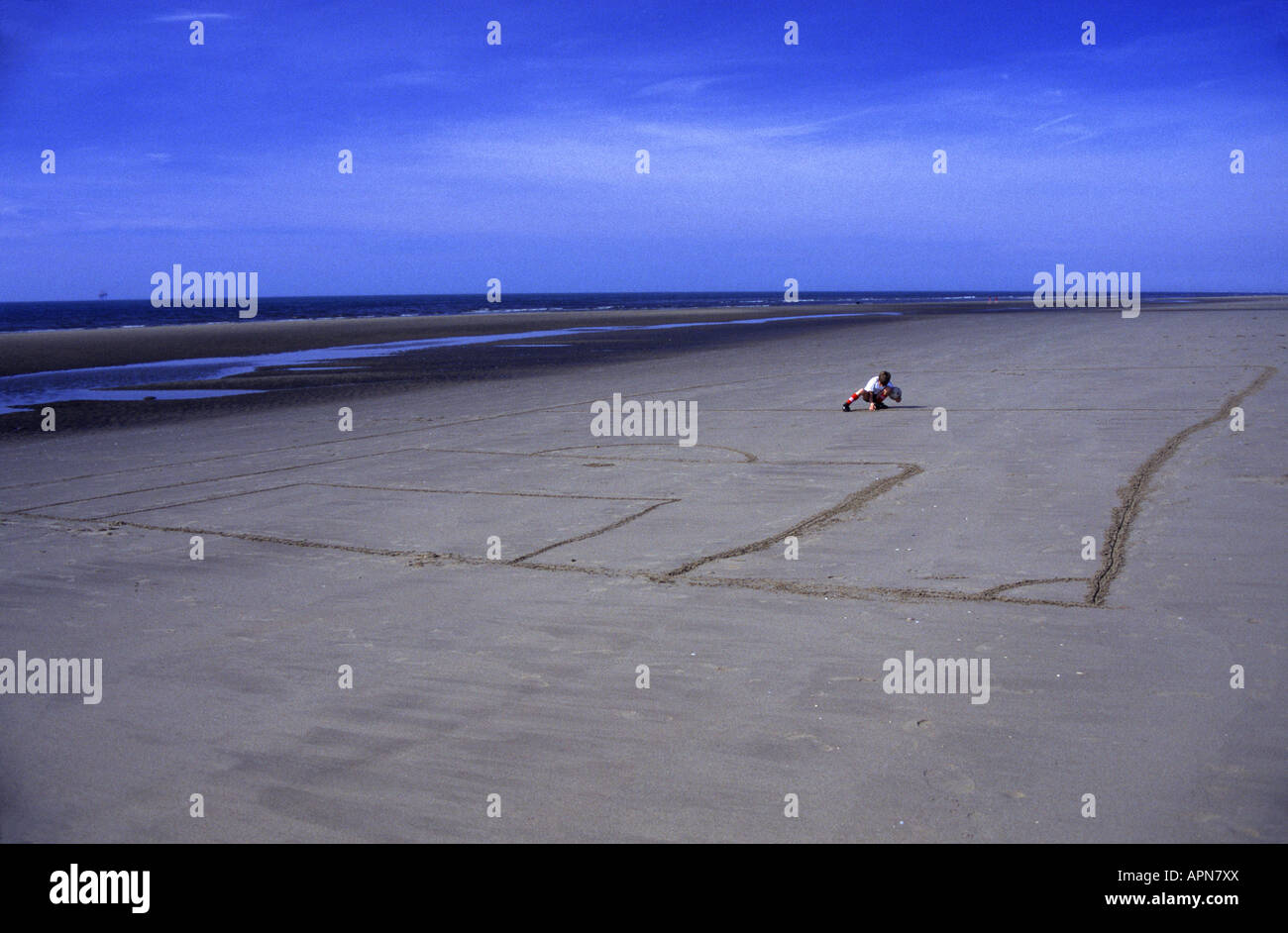 boy creating football pitch in sand on beach Stock Photo - Alamy