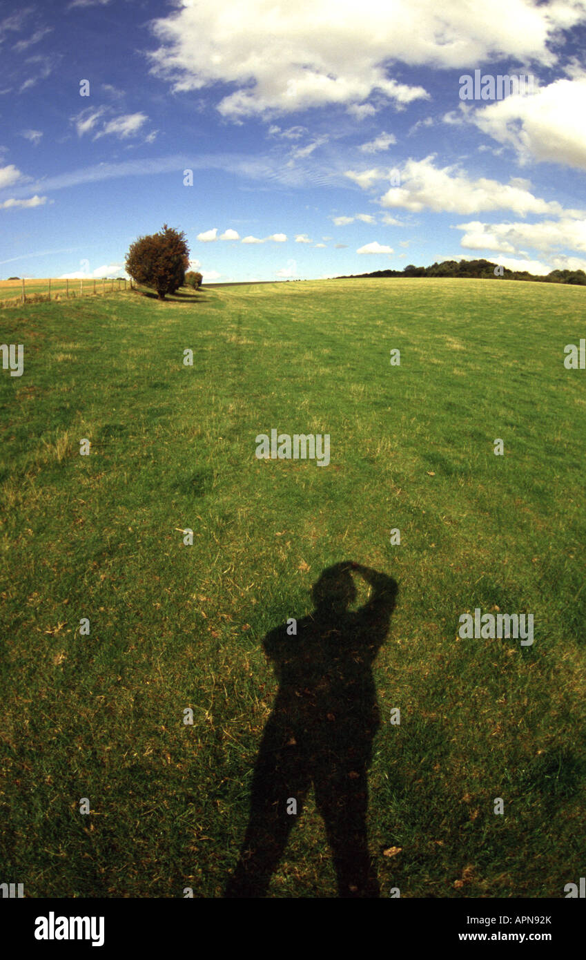 shadow of man on grass taking photographys of nature scene Stock Photo ...