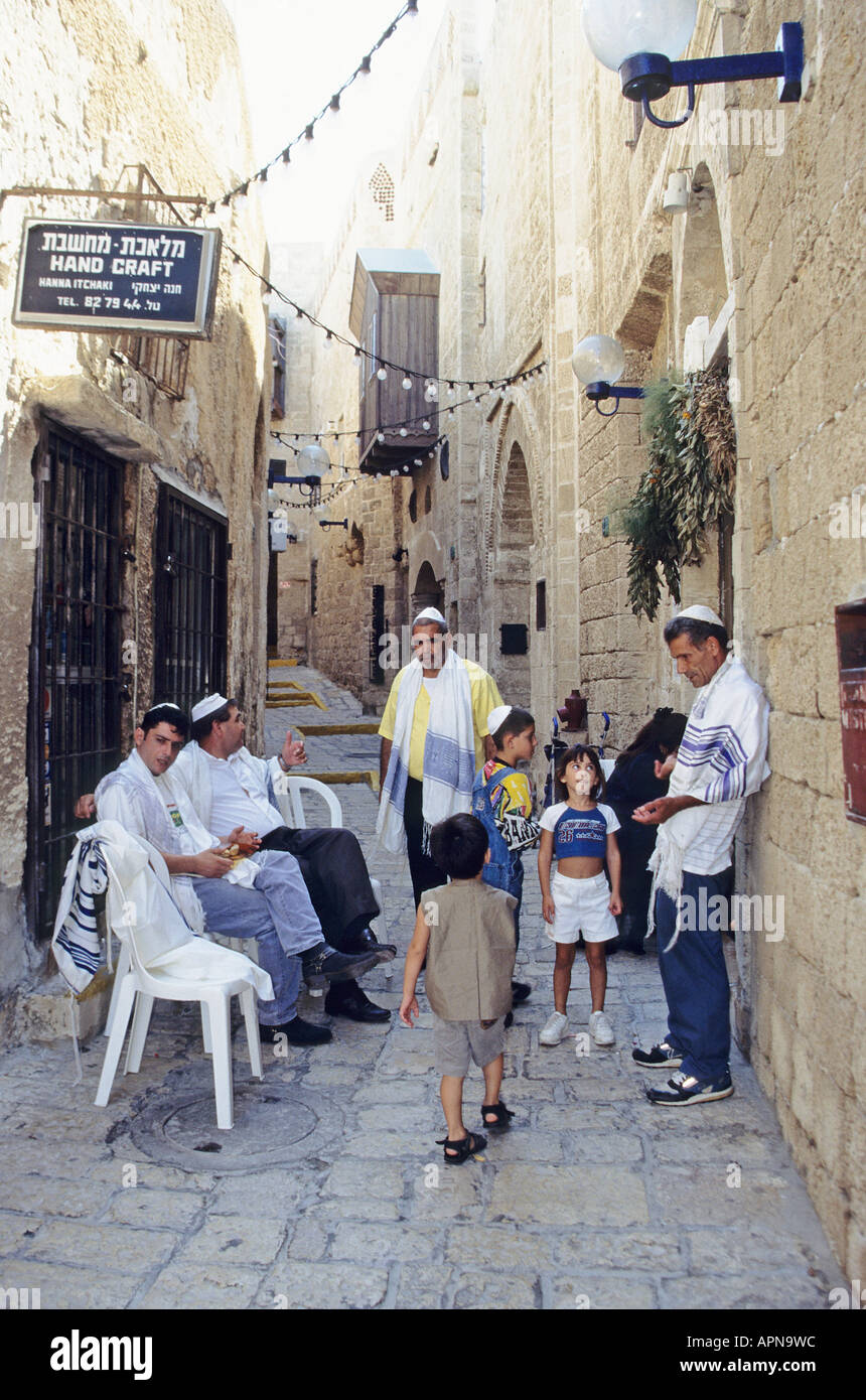 A group of Lebanese Jewish men and children in a narrow cobbled ...