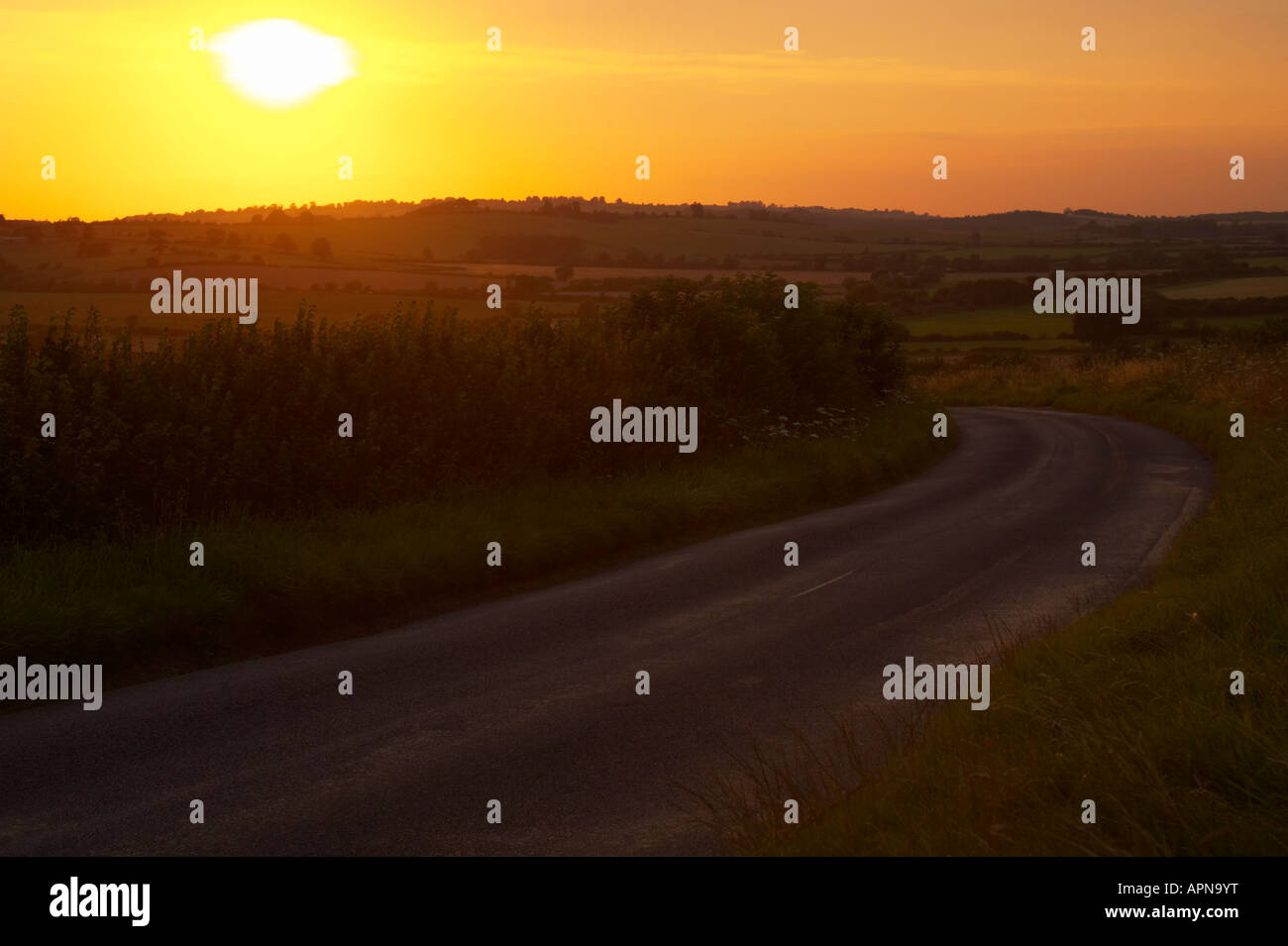 Winding road at sunset Stock Photo - Alamy