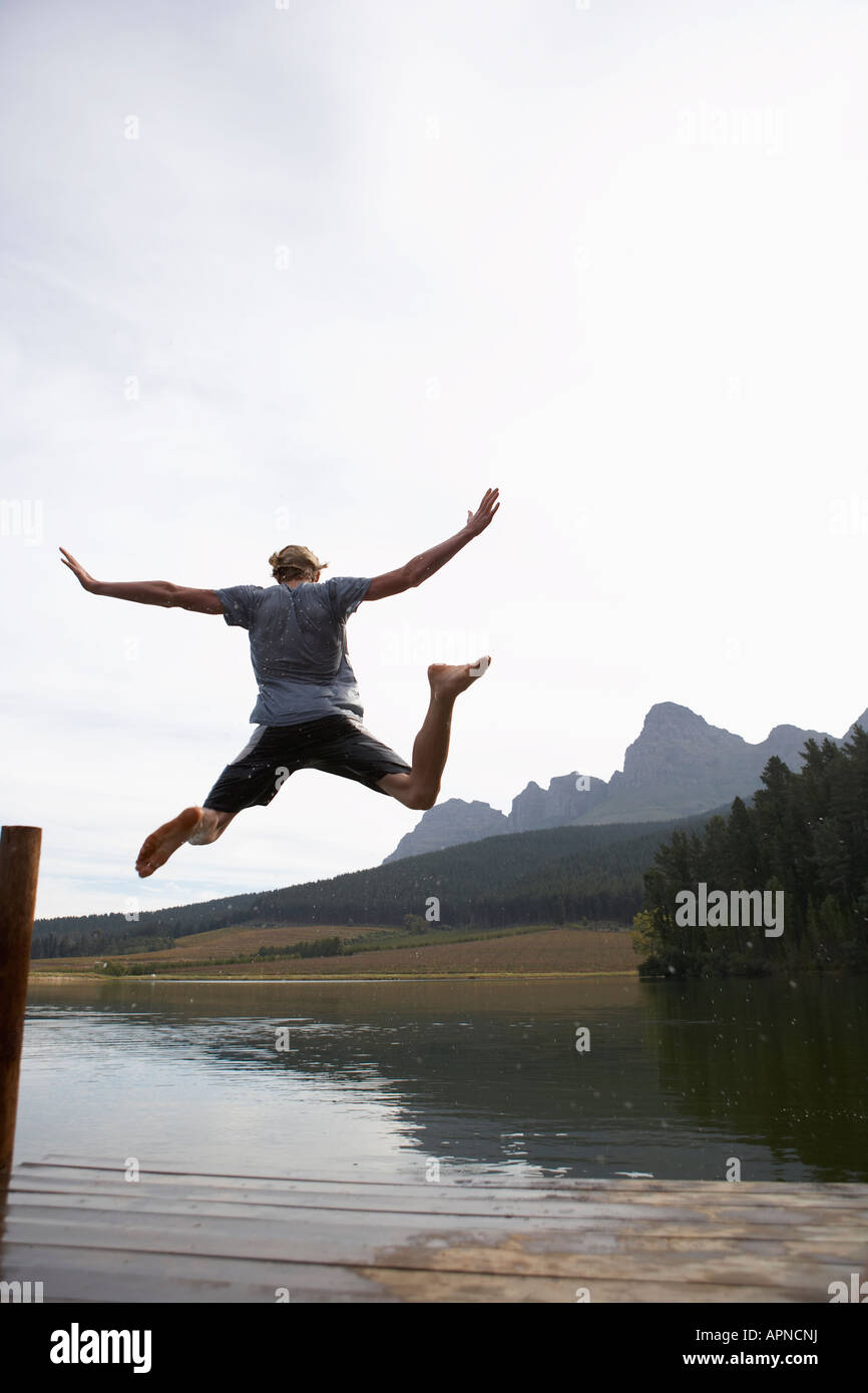 Teenage boy jumping from jetty (rear view), Cape Town, South Africa ...