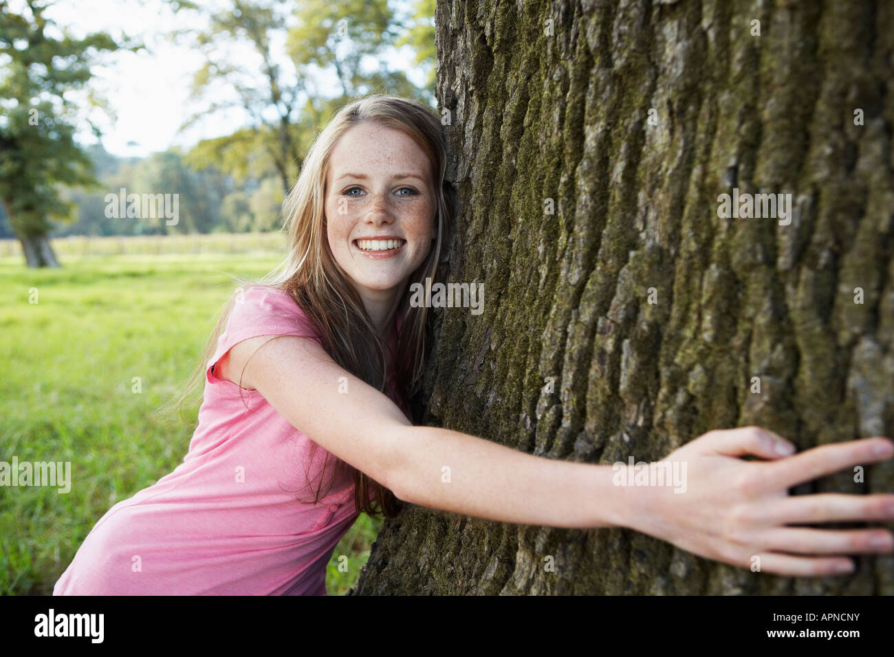 Teenage girl hugging tree Stock Photo - Alamy