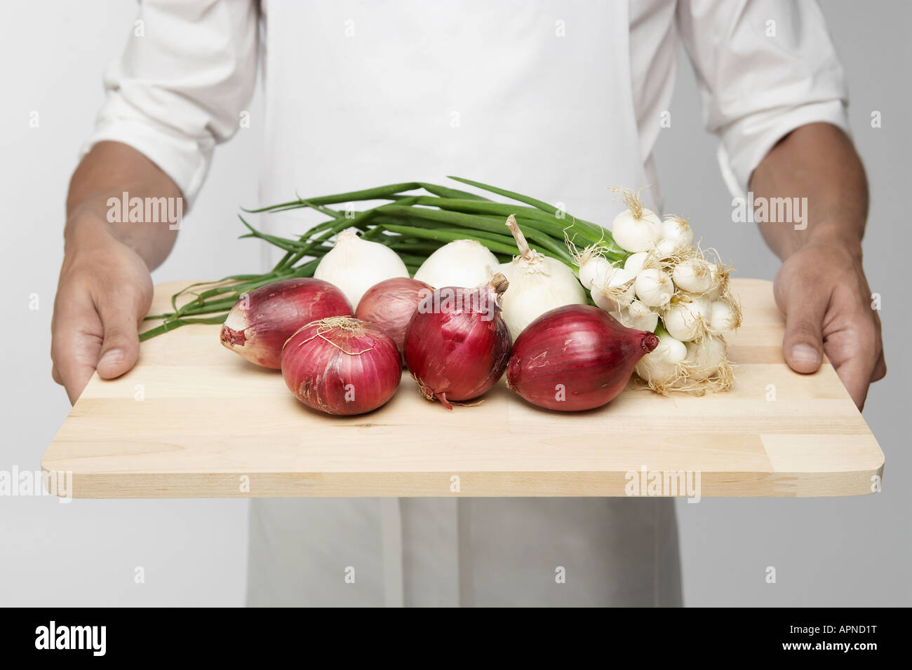 Chef holding cutting board with onions Stock Photo - Alamy