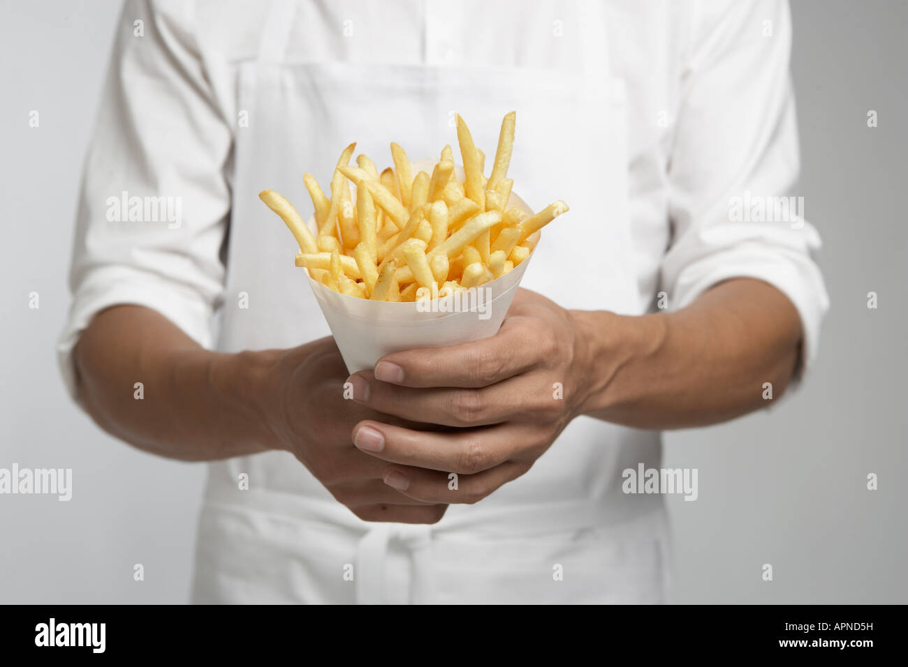 Chef holding french fries (mid section Stock Photo - Alamy