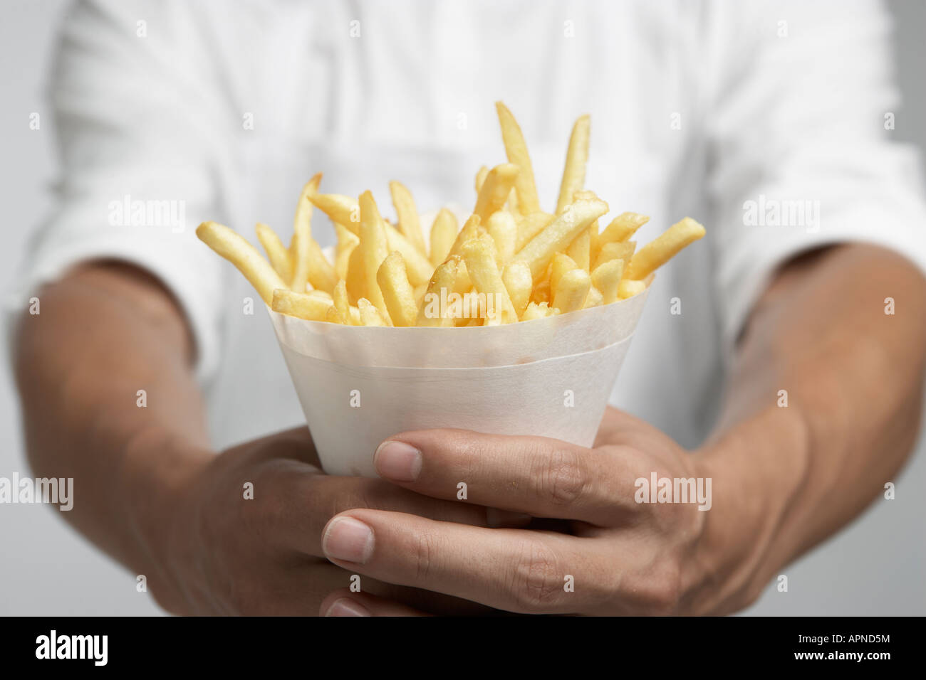 Chef holding french fries (mid section Stock Photo - Alamy