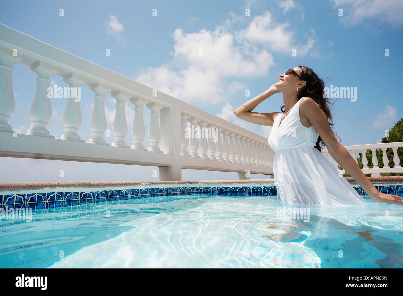 Young woman wearing dress in swimming pool Stock Photo - Alamy