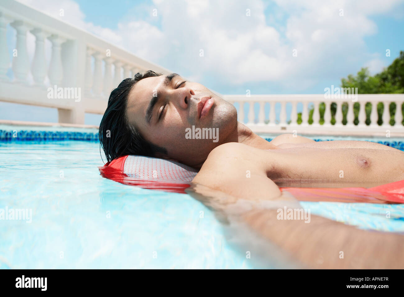 Young man lying on air mattress in swimming pool Stock Photo - Alamy