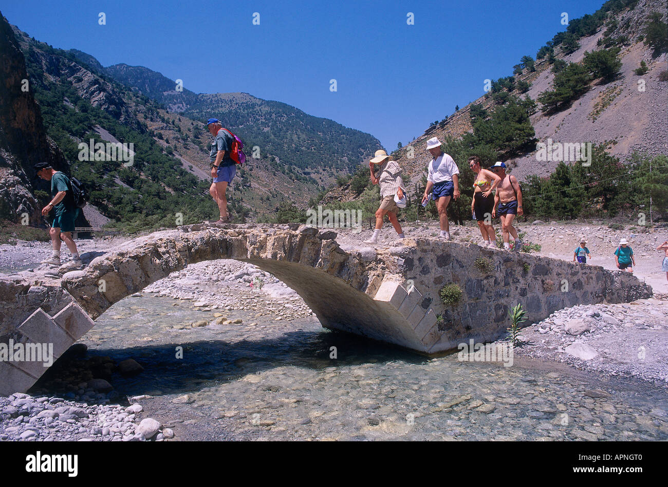 A group of walkers crossing the little arched footbridge the last ...
