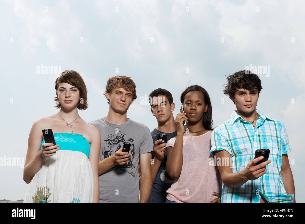 Five teenagers with mobile phones (low angle view Stock Photo - Alamy