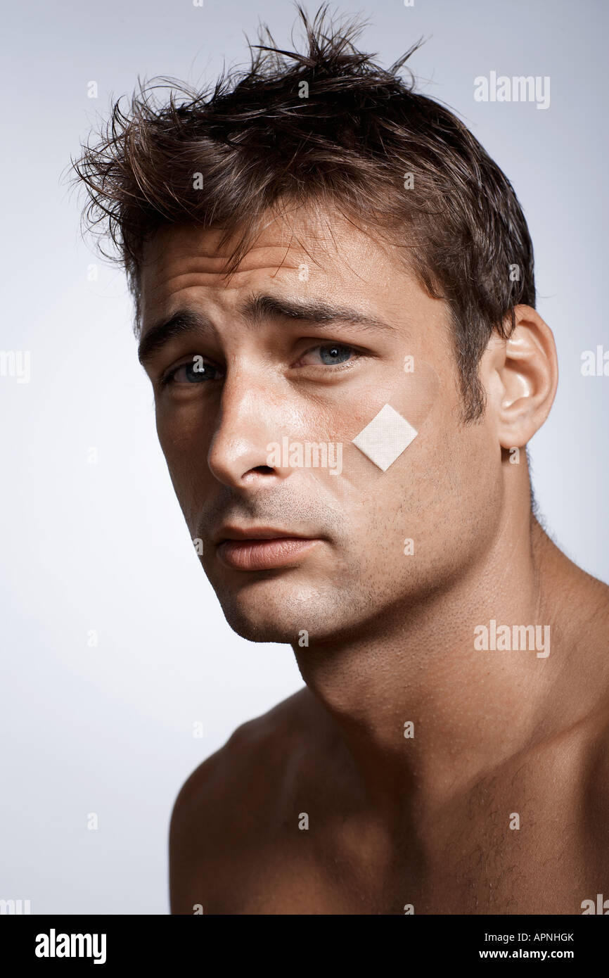Mid adult man with adhesive plaster on cheek Stock Photo - Alamy