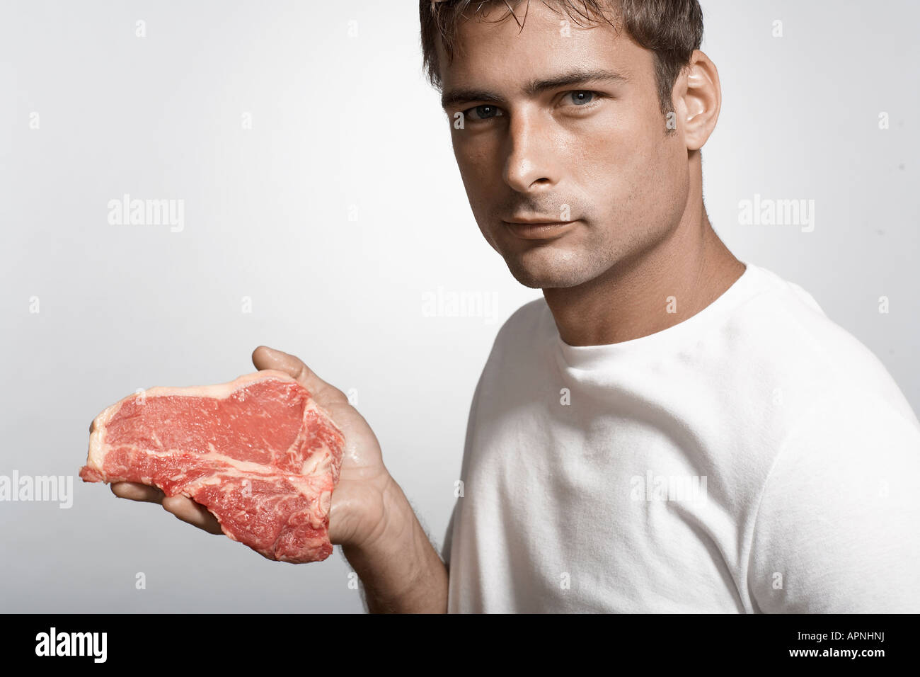 Mid adult man holding steak Stock Photo - Alamy