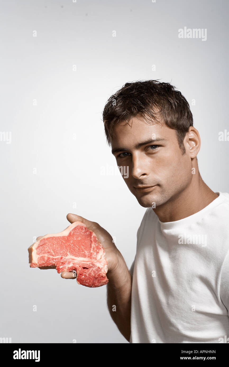 Mid adult man holding steak Stock Photo - Alamy