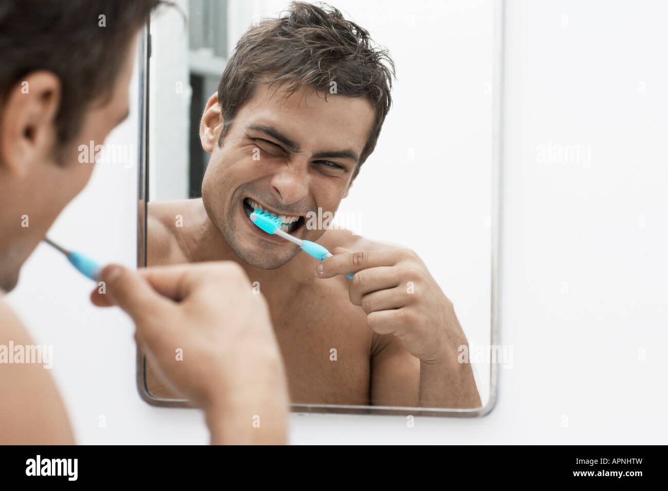 Mid adult man cleaning teeth Stock Photo - Alamy