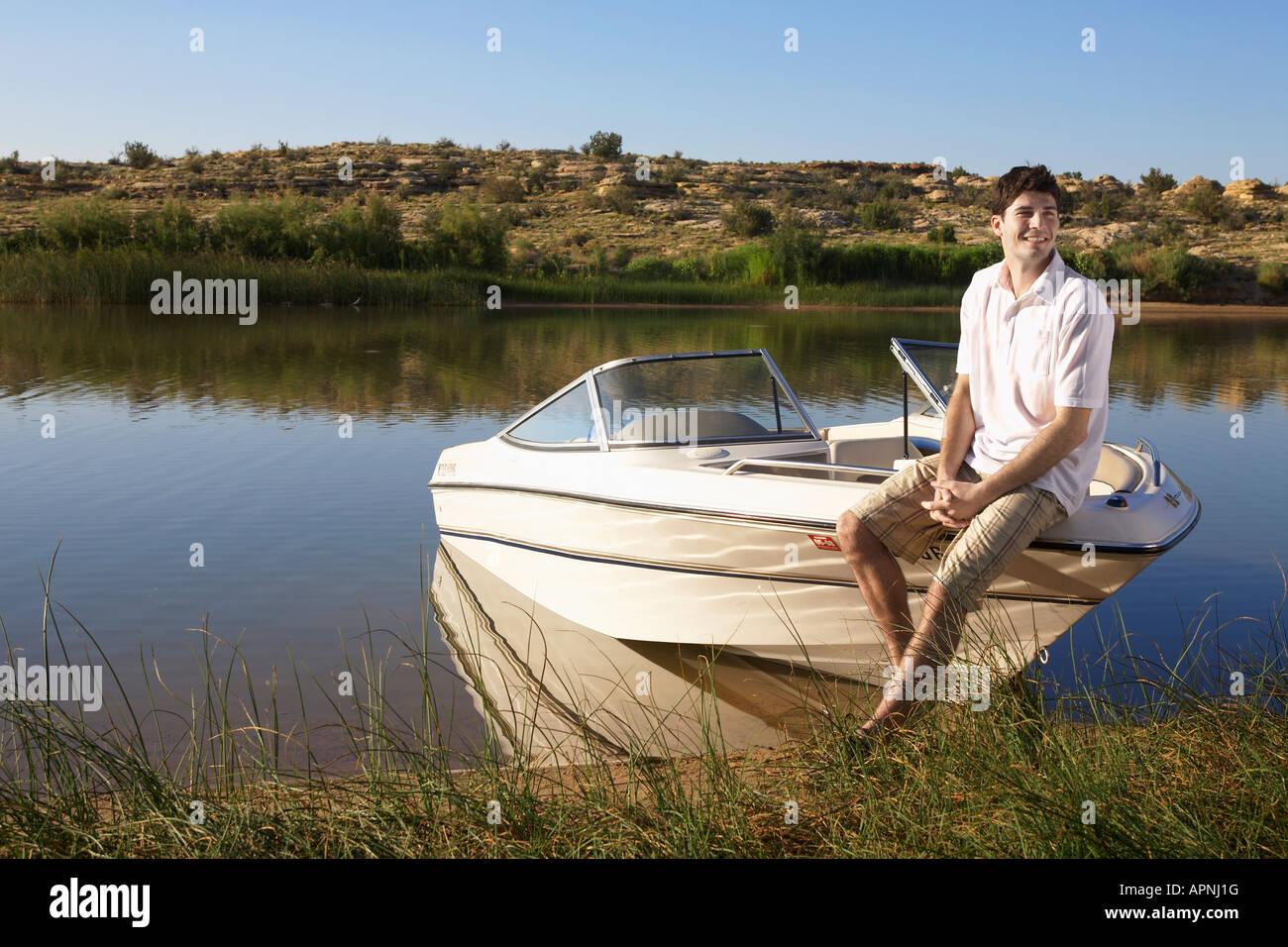 Young man sitting on motorboat Stock Photo - Alamy