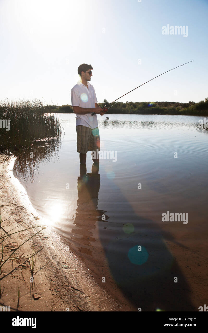 Young man fly fishing Stock Photo - Alamy