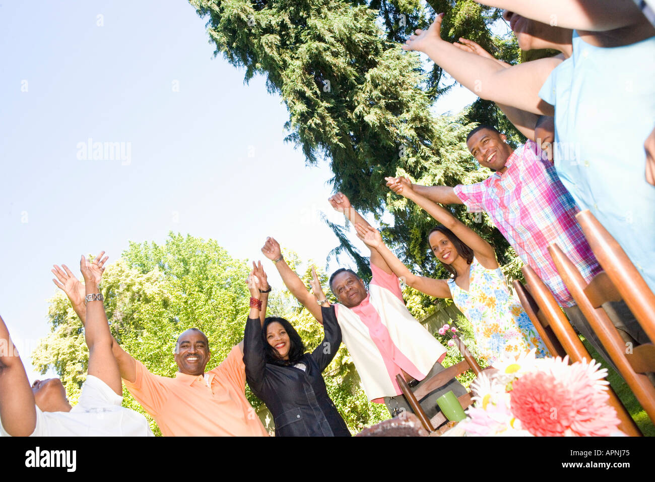 Family with upraised arms at picnic Stock Photo - Alamy