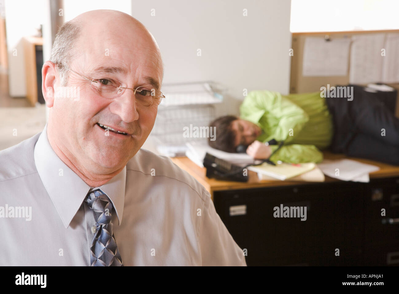 Portrait of boss with sleeping employee Stock Photo - Alamy