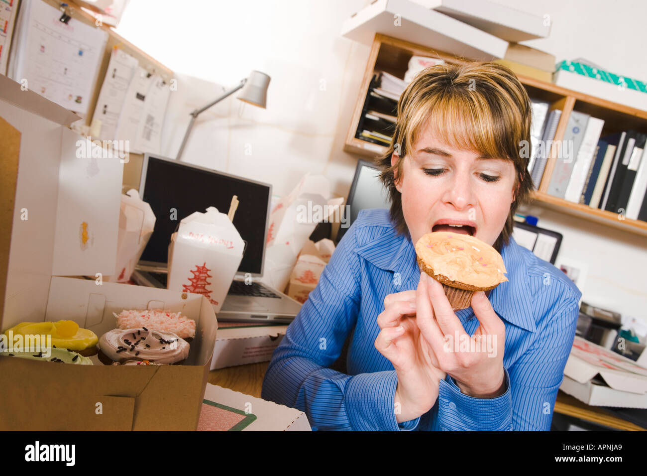 Office worker eating at her desk Stock Photo - Alamy