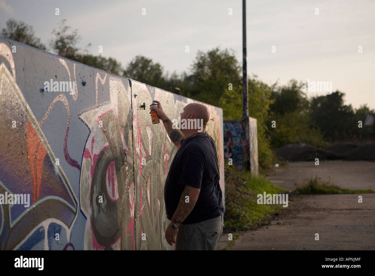 man spray painting a wall Stock Photo - Alamy