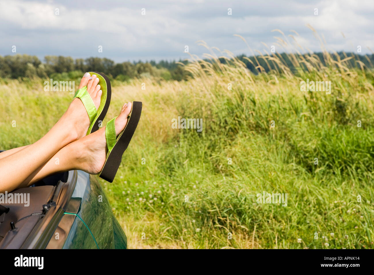 Woman resting feet on car Stock Photo - Alamy