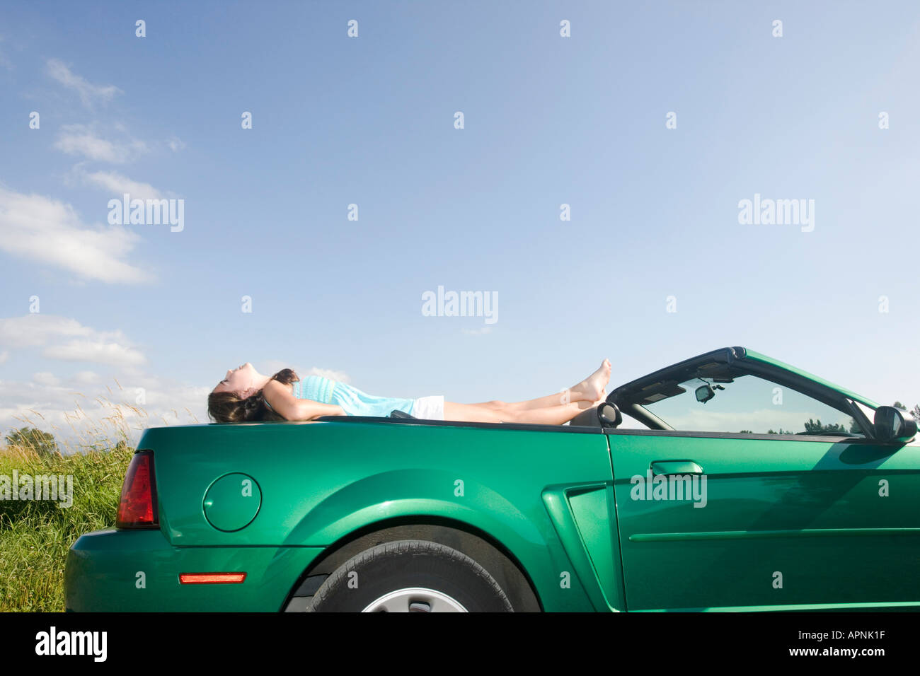 Girl relaxing on car Stock Photo - Alamy