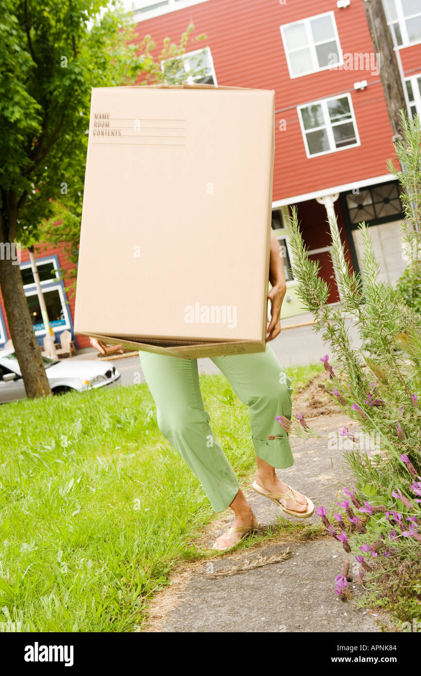 Woman carrying a heavy box Stock Photo - Alamy