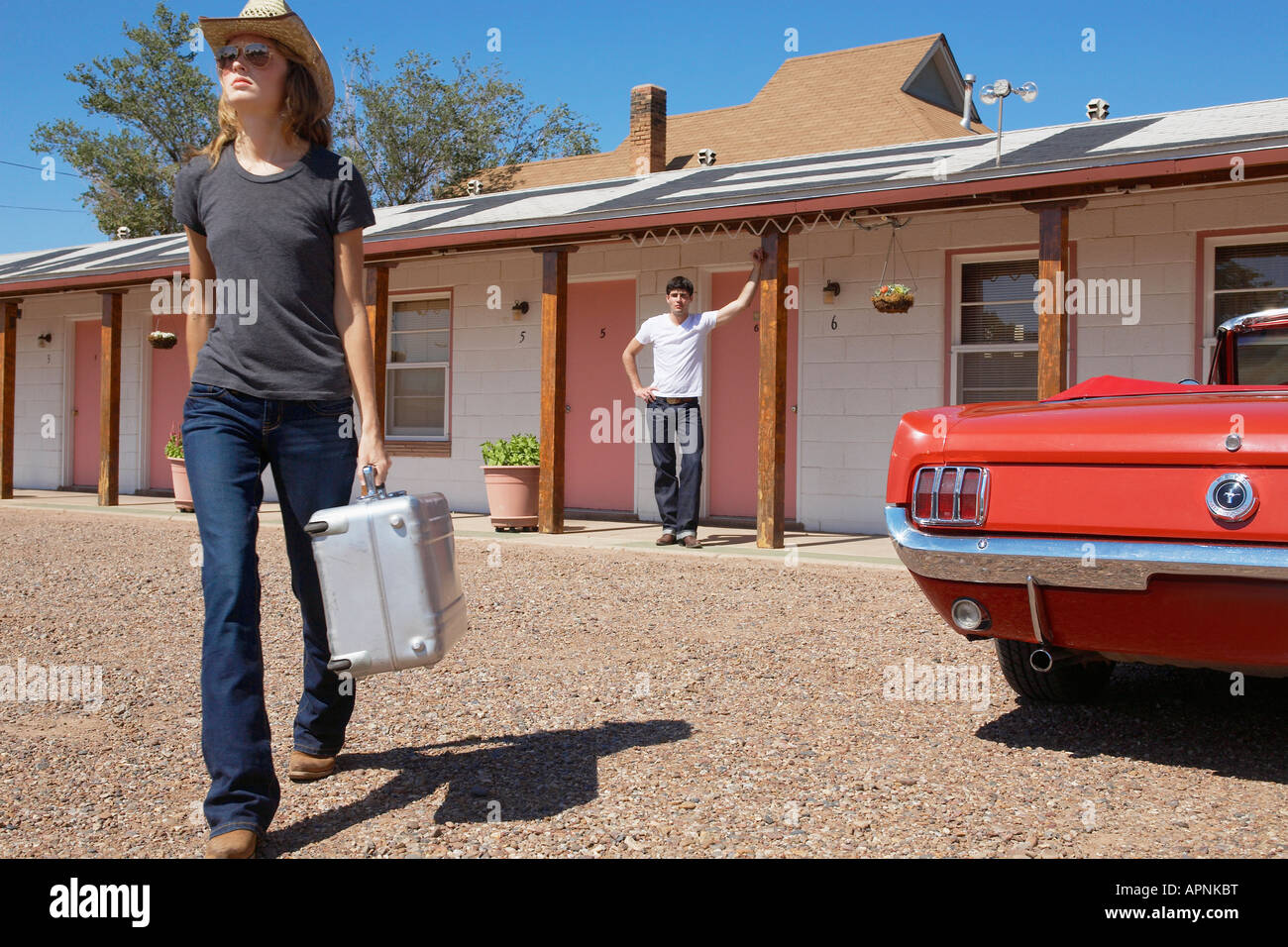 Girlfriend leaving motel, boyfriend looking in background Stock Photo ...