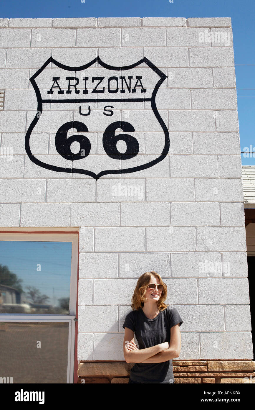 Young woman standing below Route 66 sign Stock Photo - Alamy