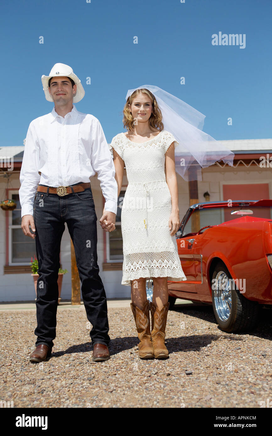 Portrait of newlyweds in cowboy attire at motel (low angle view Stock ...