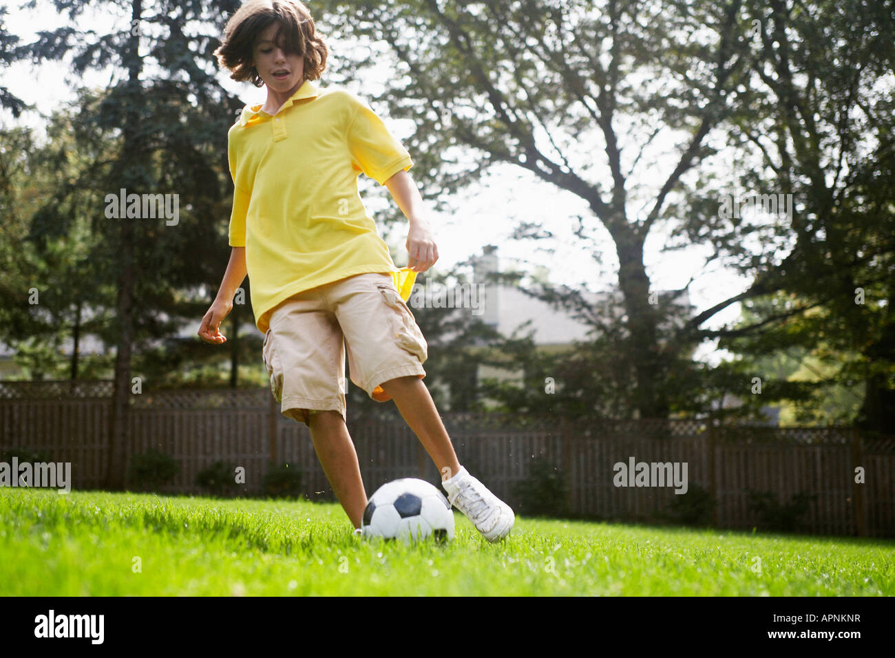 Boy (12-13) playing with soccer ball Stock Photo - Alamy
