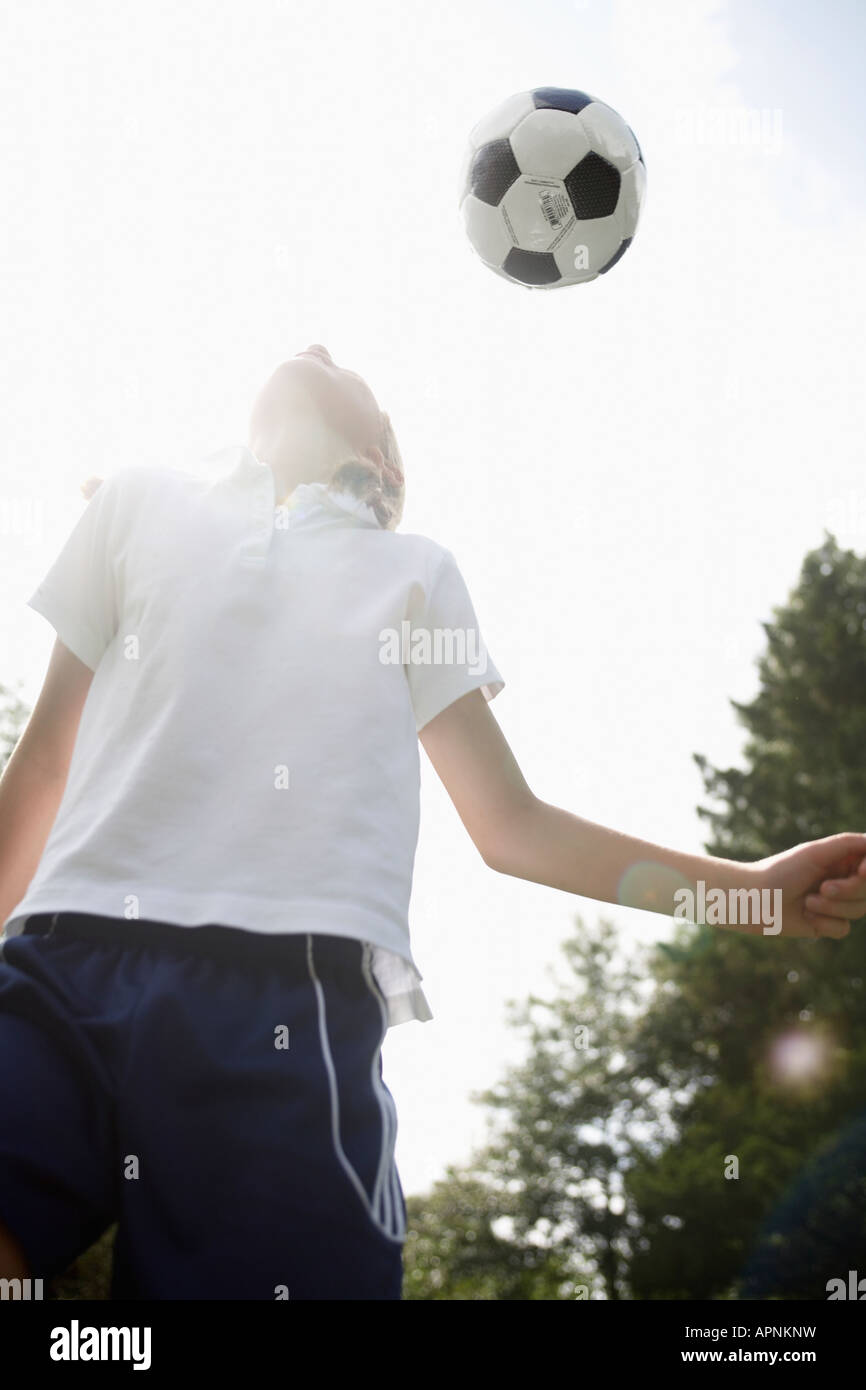 Girl (10-11) heading a soccer ball Stock Photo - Alamy
