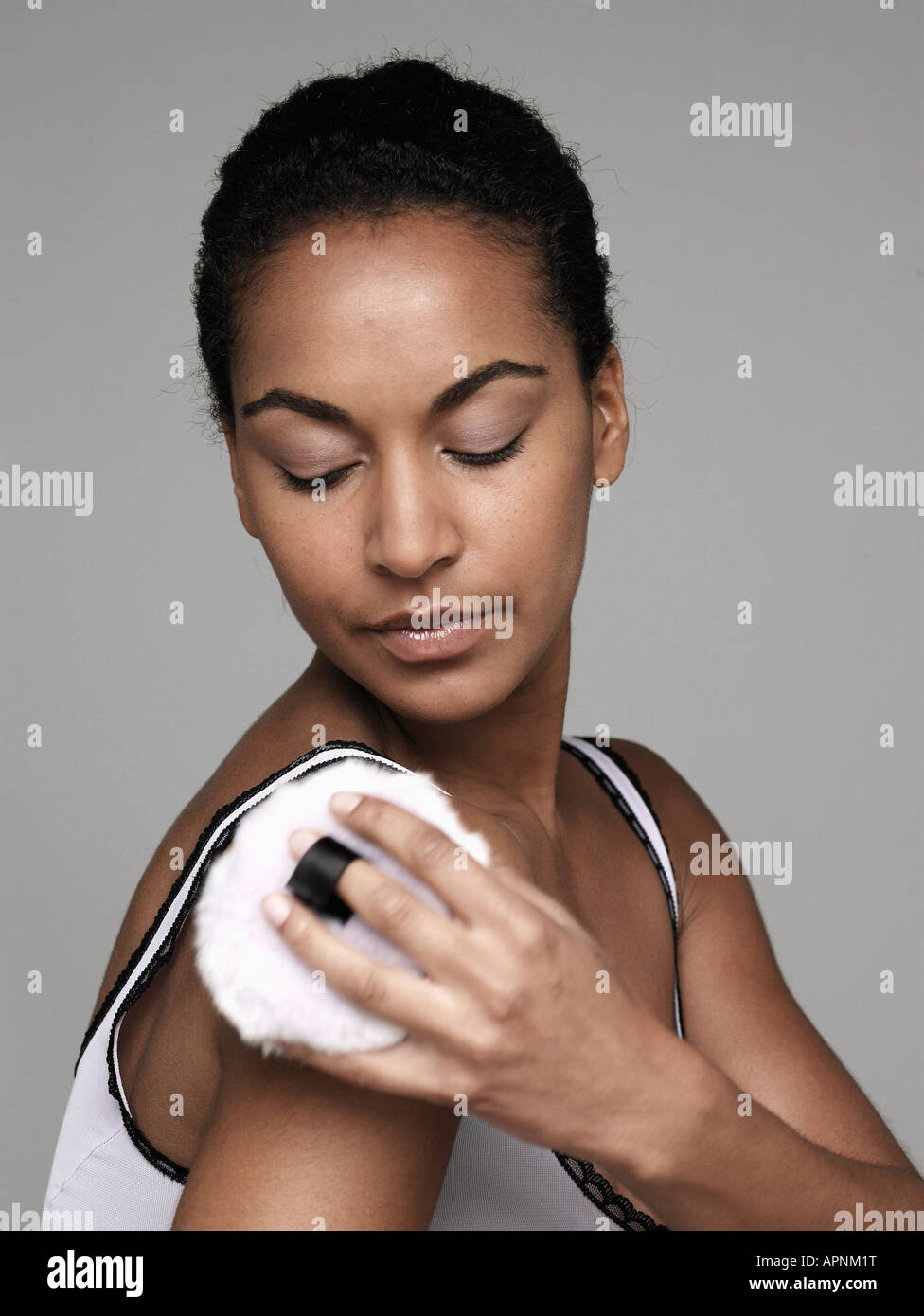 Young woman rubbing skin with sponge Stock Photo - Alamy