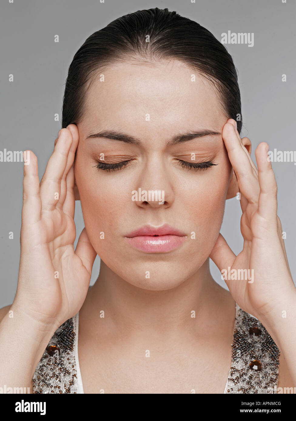 Young woman rubbing temples Stock Photo - Alamy