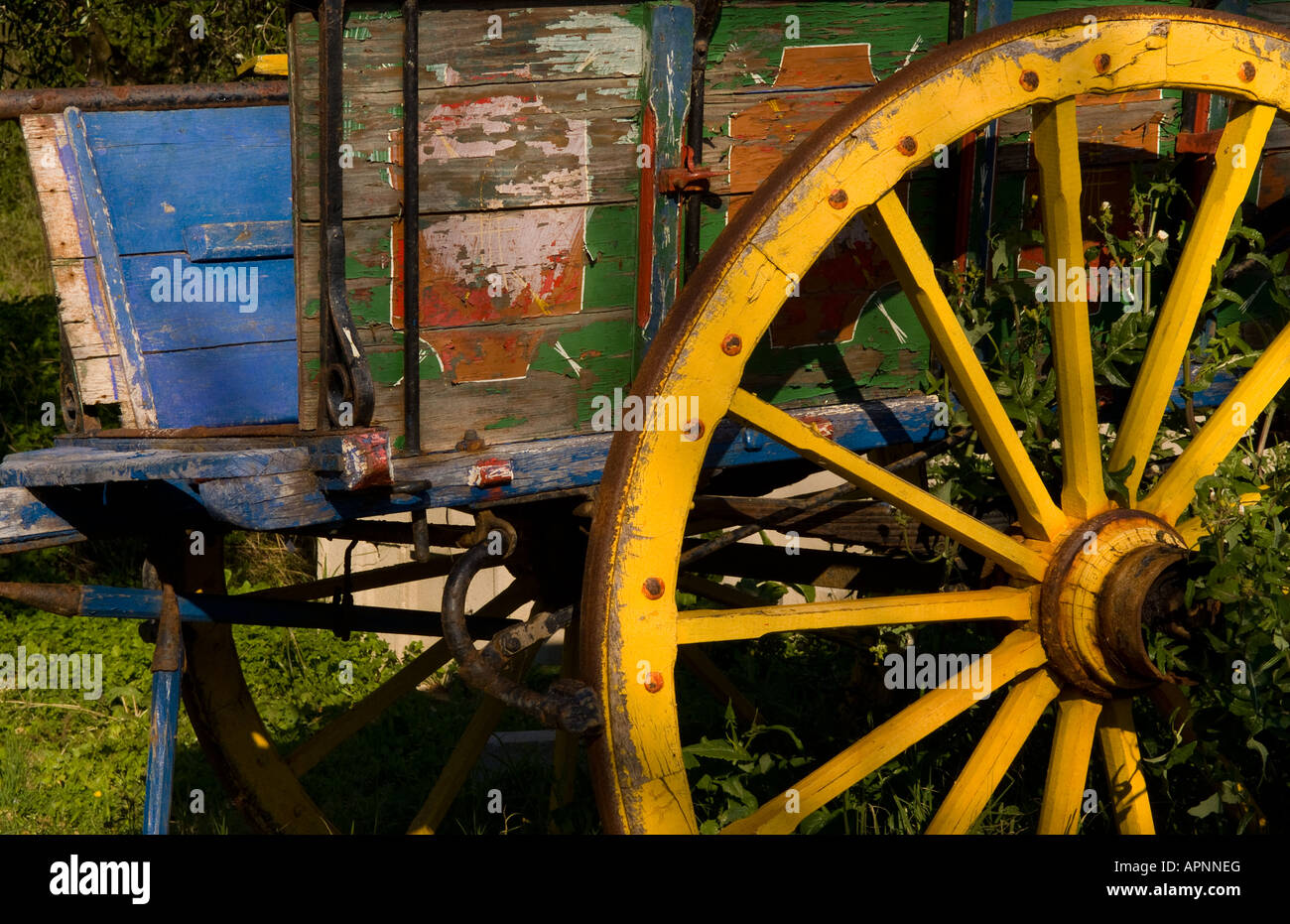 Beautiful colorful wagon and wheel in yard near Vila de Bispo in ...