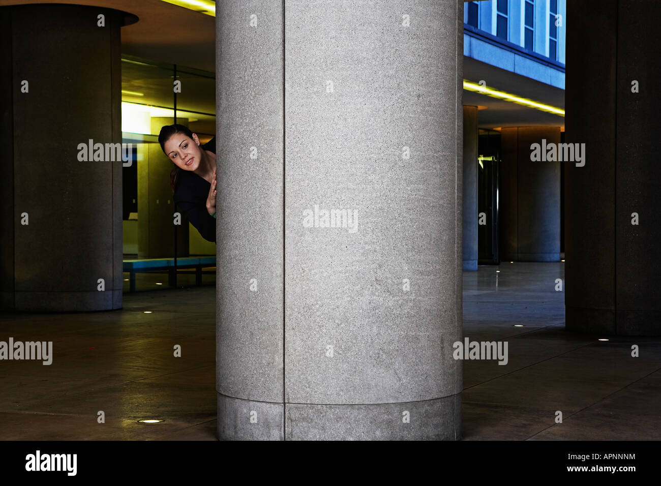 Businesswoman Hiding Behind Column Stock Photo - Alamy